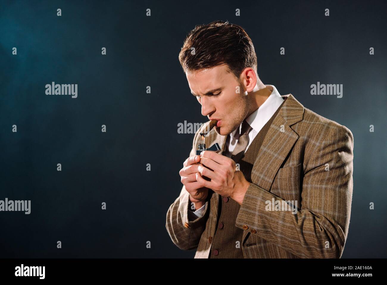 handsome gangster smoking cigar on black Stock Photo - Alamy