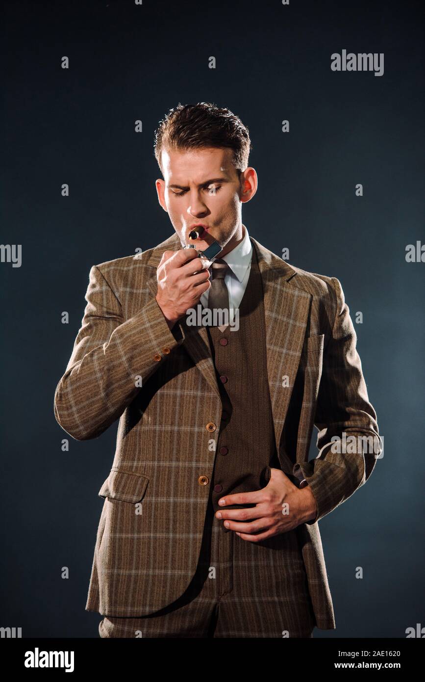 handsome gangster in suit smoking cigar on black Stock Photo - Alamy