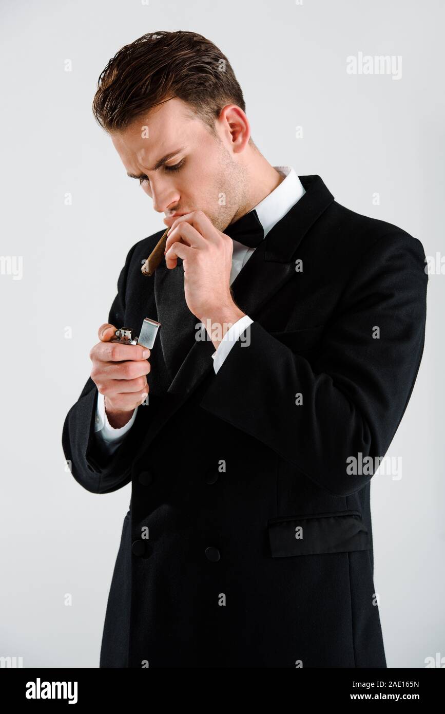 handsome and rich man smoking cigar and holding lighter isolated on ...