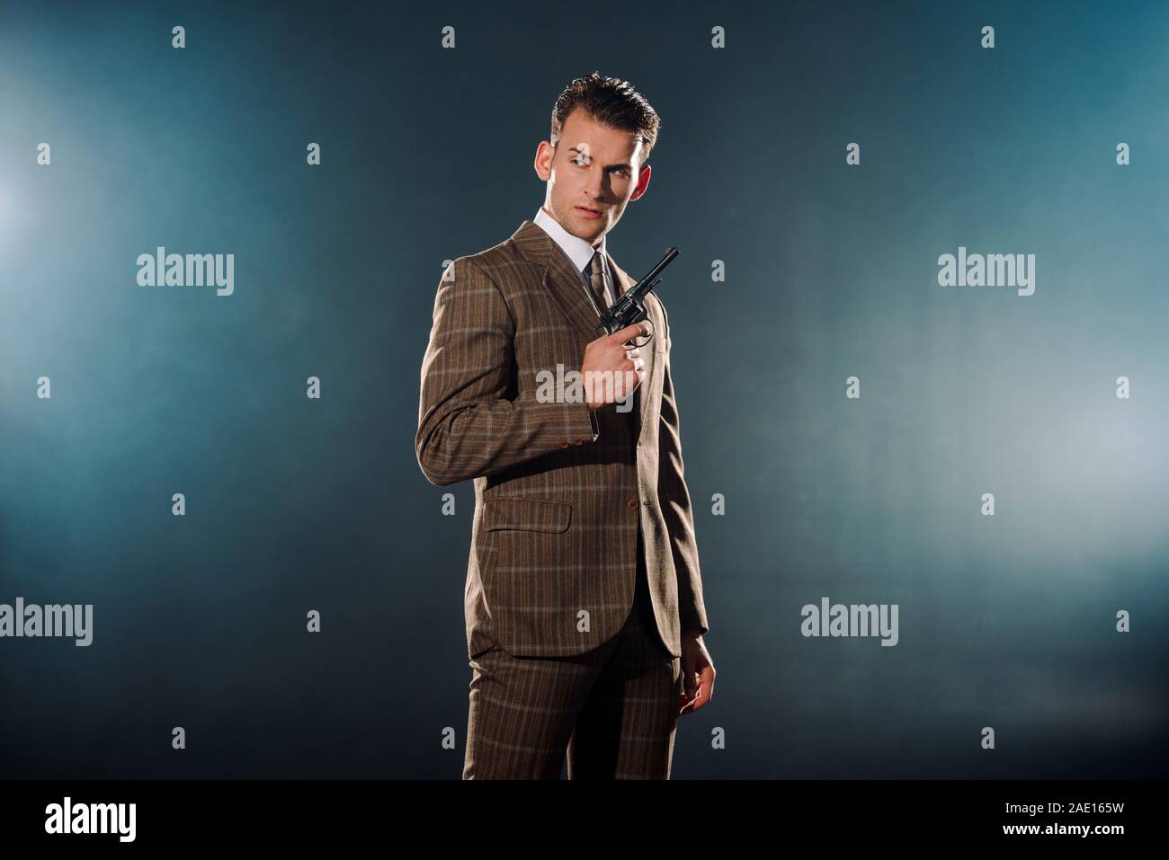 dangerous man in formal wear holding gun on black Stock Photo - Alamy