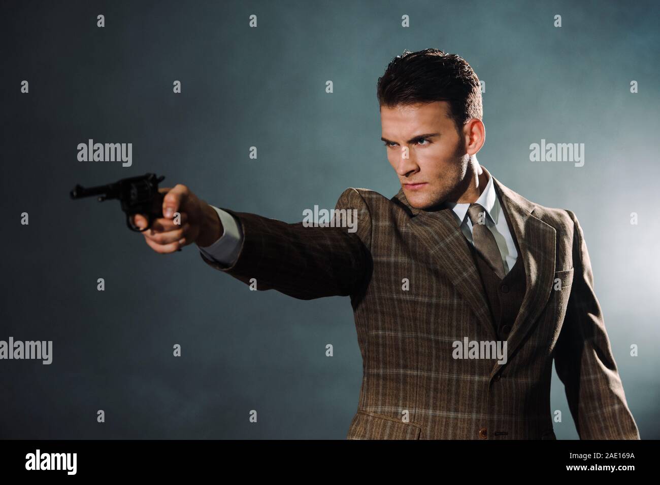 handsome armed man holding gun on black Stock Photo - Alamy
