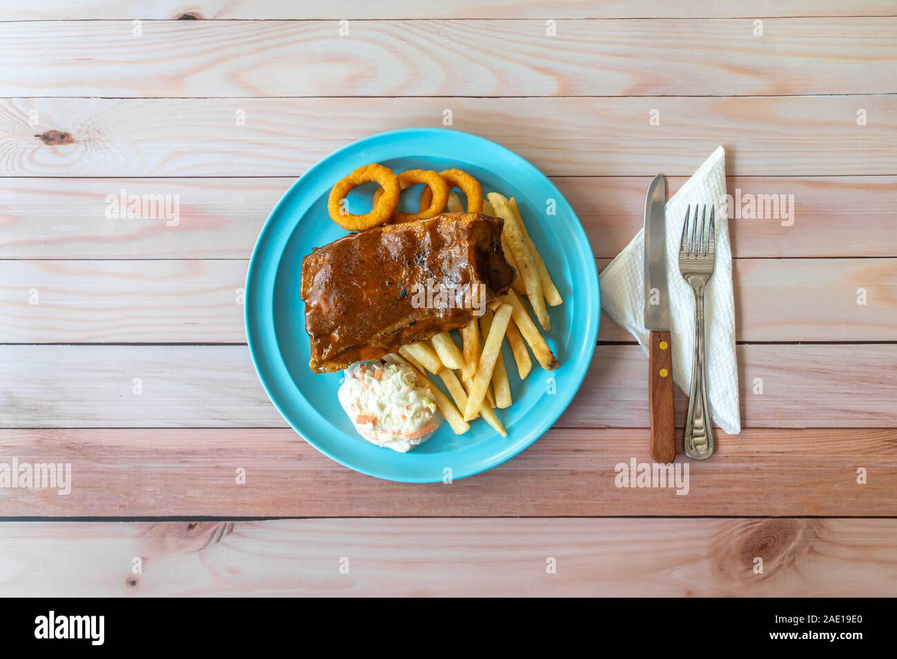 Western food on table - BBQ pork ribs, onion rings, french fries and ...