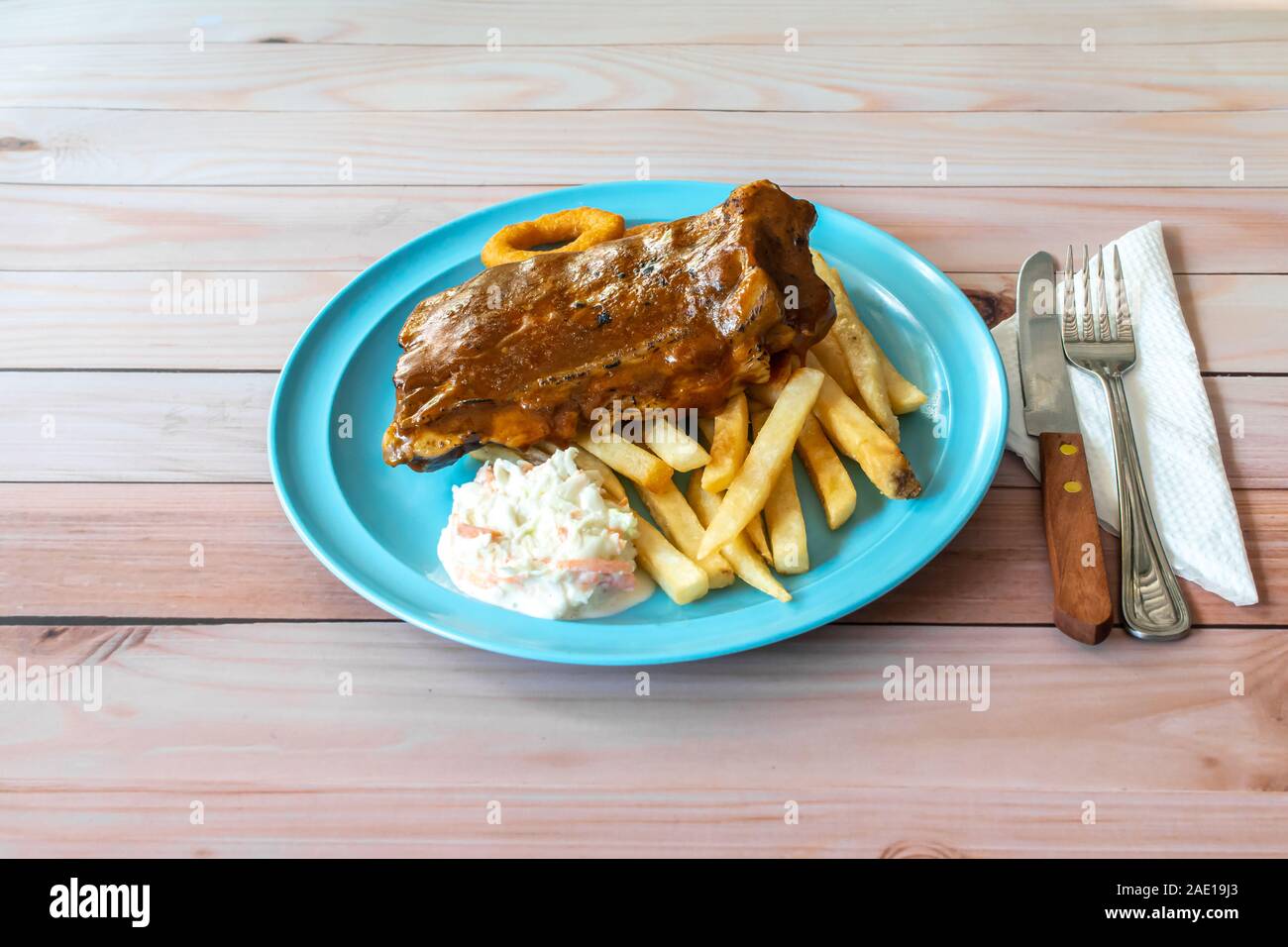 Western food on table - BBQ pork ribs, onion rings, french fries and ...