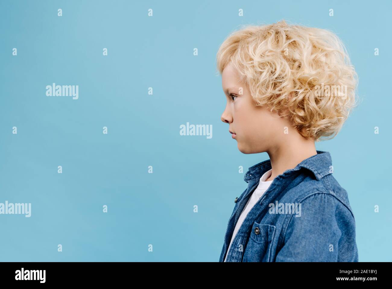 side view of cute kid looking away isolated on blue Stock Photo - Alamy