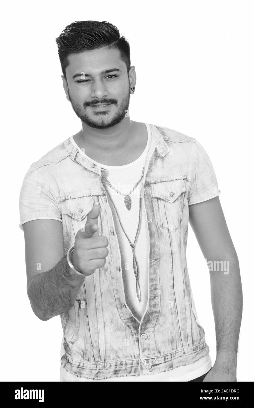Young happy handsome Indian man winking and pointing finger Stock Photo ...
