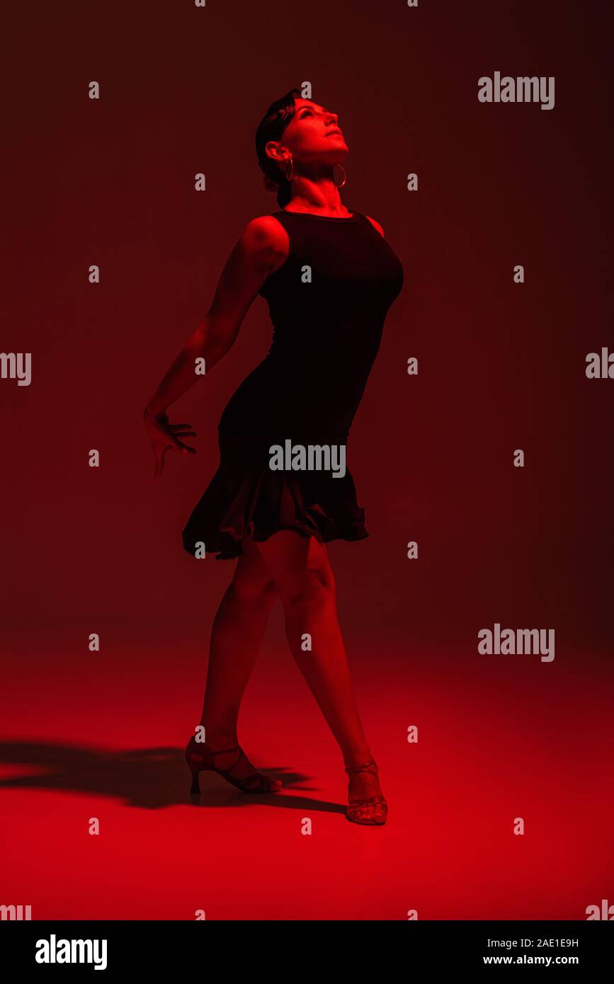 beautiful dancer in black dress performing tango on dark background ...