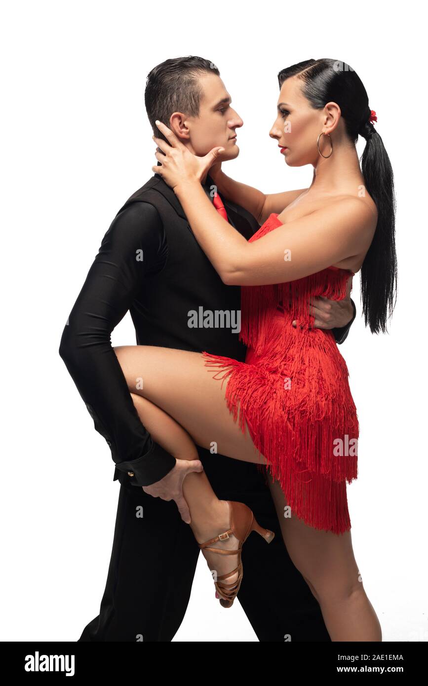 Sensual Dancer Supporting Leg Of Attractive Partner While Performing Tango Isolated On White