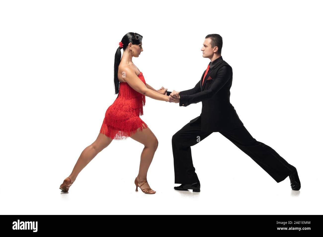 side view of elegant dancers holding hands and looking at each other ...