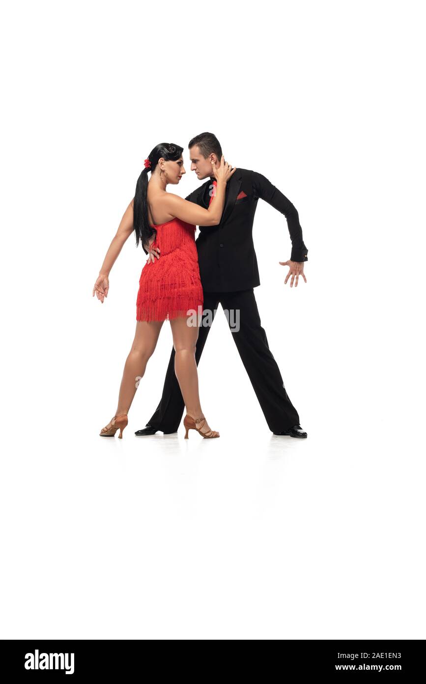elegant dancers looking at each other while performing tango on white ...