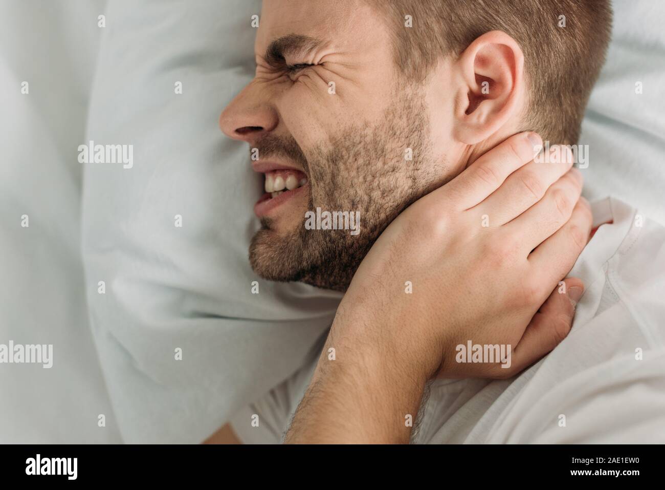 top view of young man touching neck while suffering from pain Stock ...
