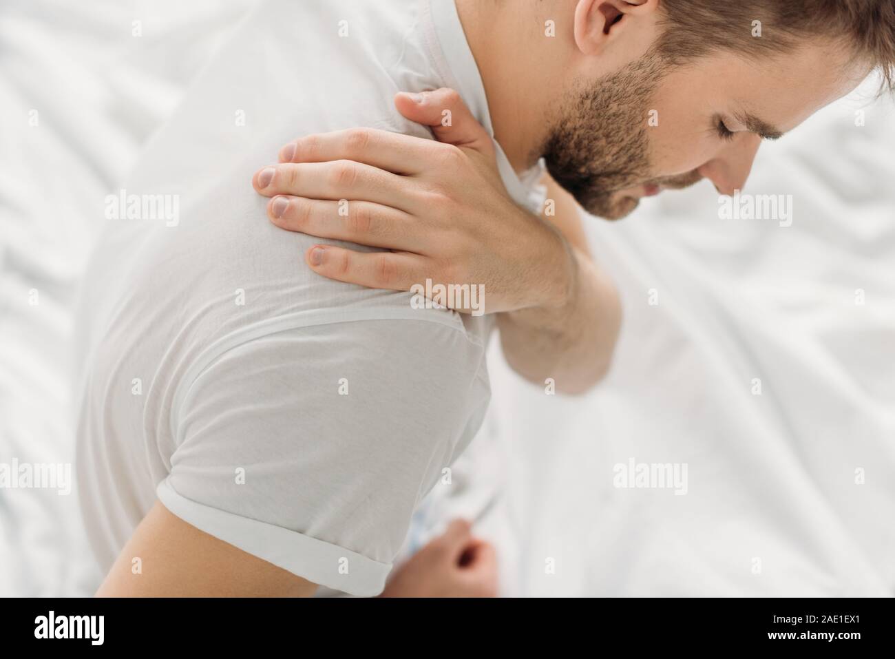 overhead view of man touching shoulder while suffering from pain Stock ...