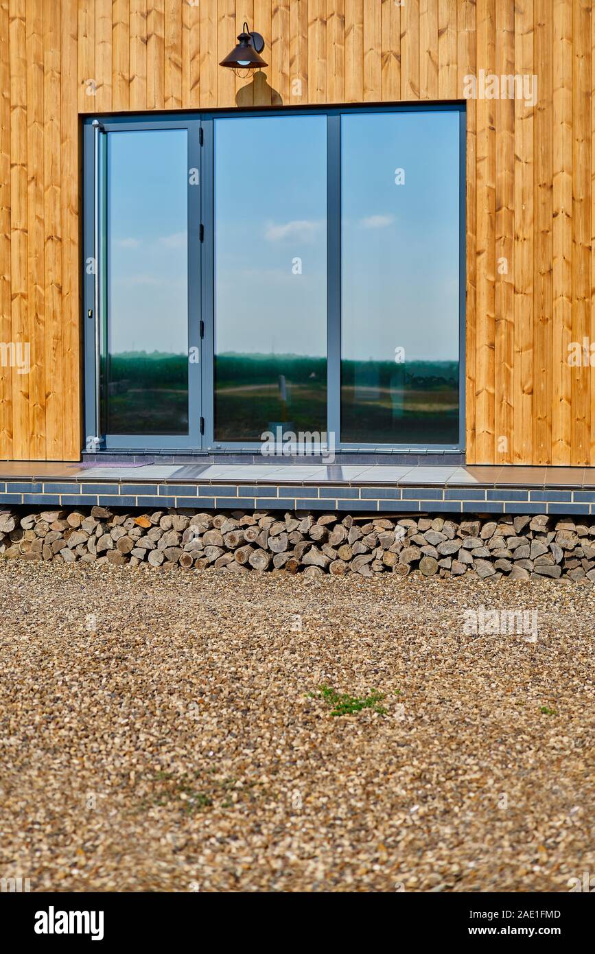Wooden facade of wooden house. Yellow wooden planking. Panorama windows ...
