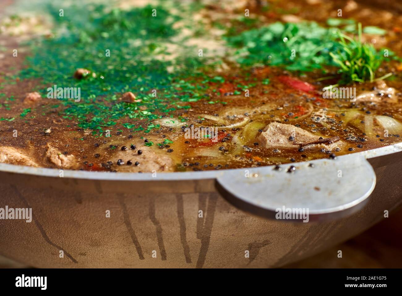 The process of making soup from lamb - shurpa in a cauldron in the open ...