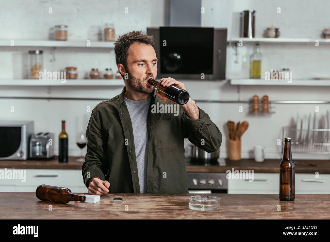 Man with alcohol depended drinking beer at kitchen Stock Photo - Alamy