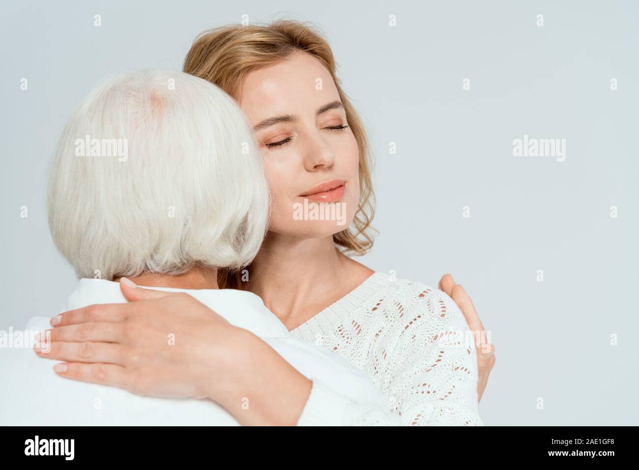 back view of mother hugging attractive daughter isolated on grey Stock ...