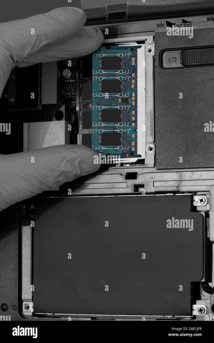Technician installing RAM into the memory slot on a laptop computer ... Technician installing RAM into the memory slot on a laptop computer ...