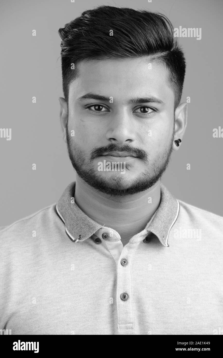 Face of young handsome bearded Indian man in black and white Stock ...