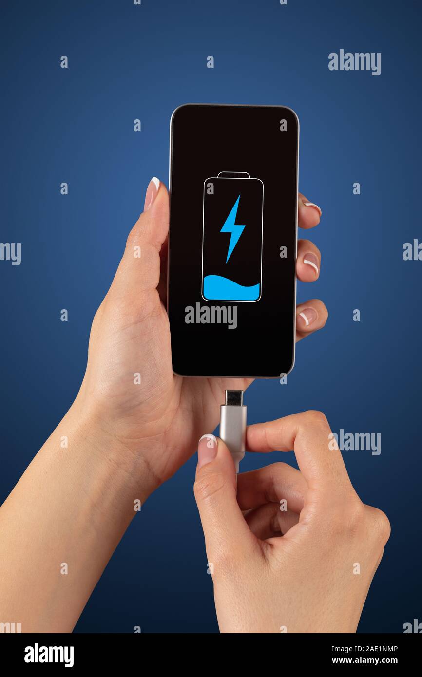 Elegant hand charging cellphone with low battery Stock Photo - Alamy