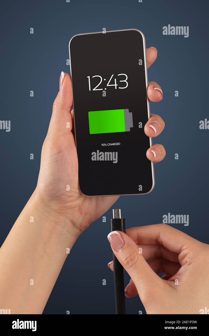 Elegant hand charging smartphone with low battery Stock Photo - Alamy