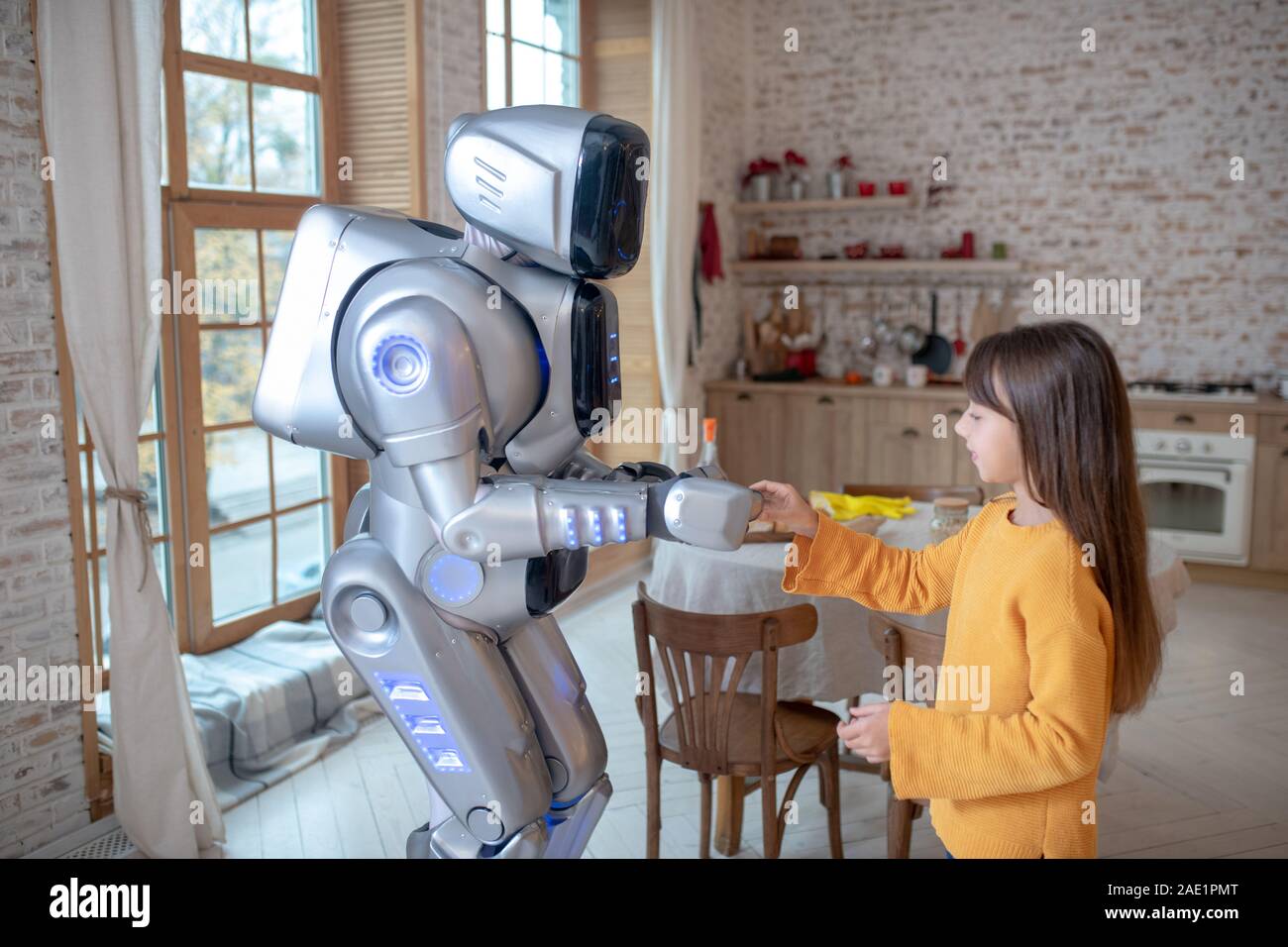 Robot and a cute girl standing in the kitchen Stock Photo - Alamy