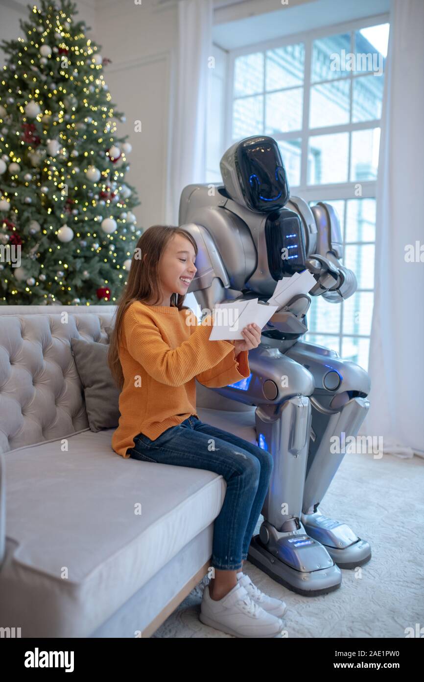 Robot and a cute girl sitting on the sofa Stock Photo - Alamy
