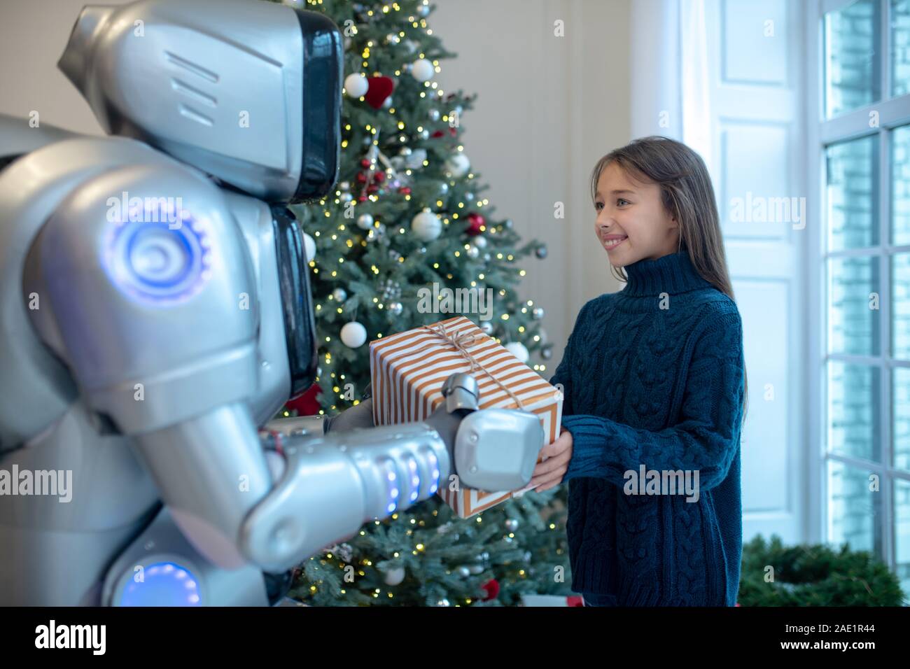 Robot giving a present to a smiling girl Stock Photo - Alamy