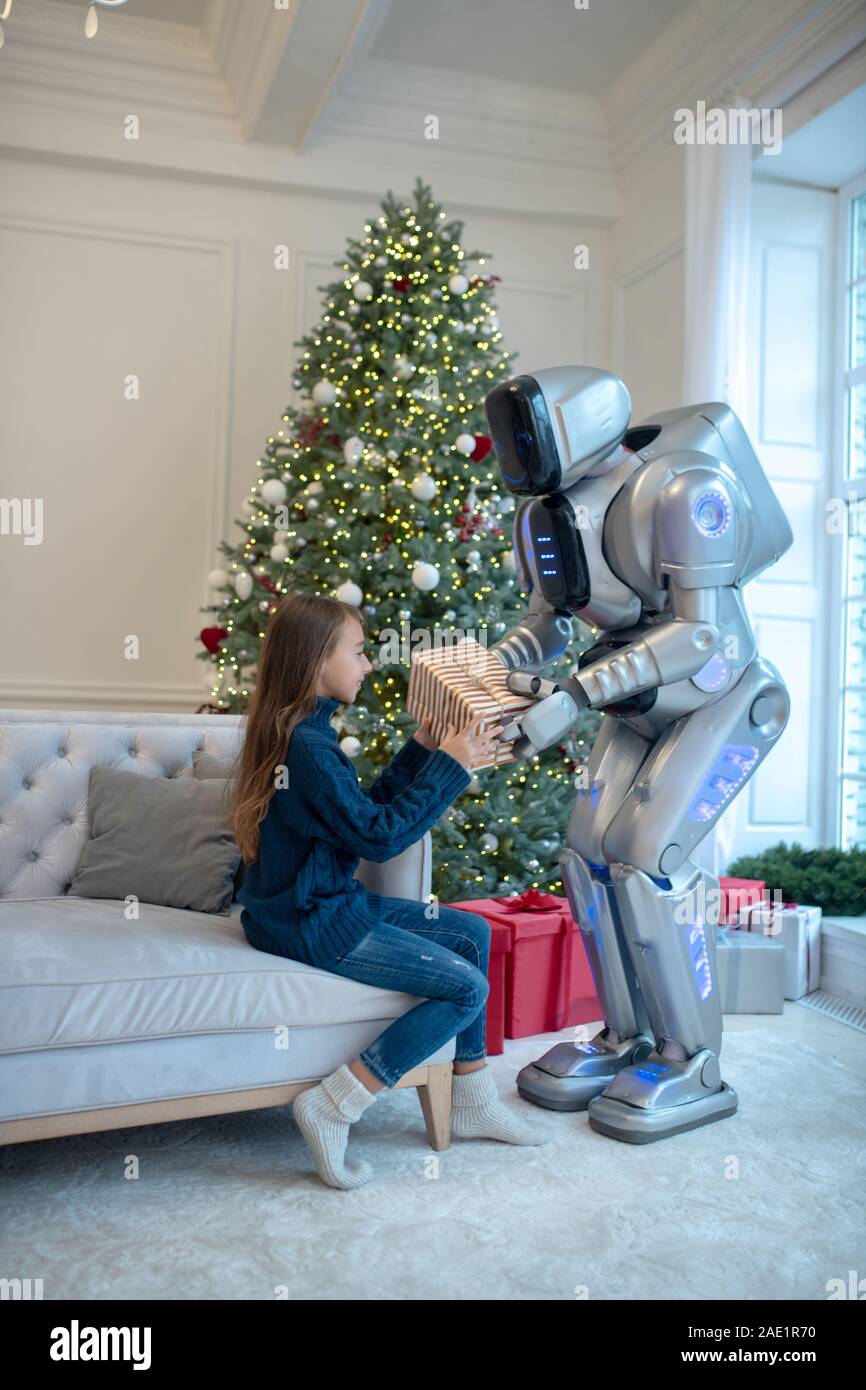 Robot giving a new year gift to the girl Stock Photo - Alamy