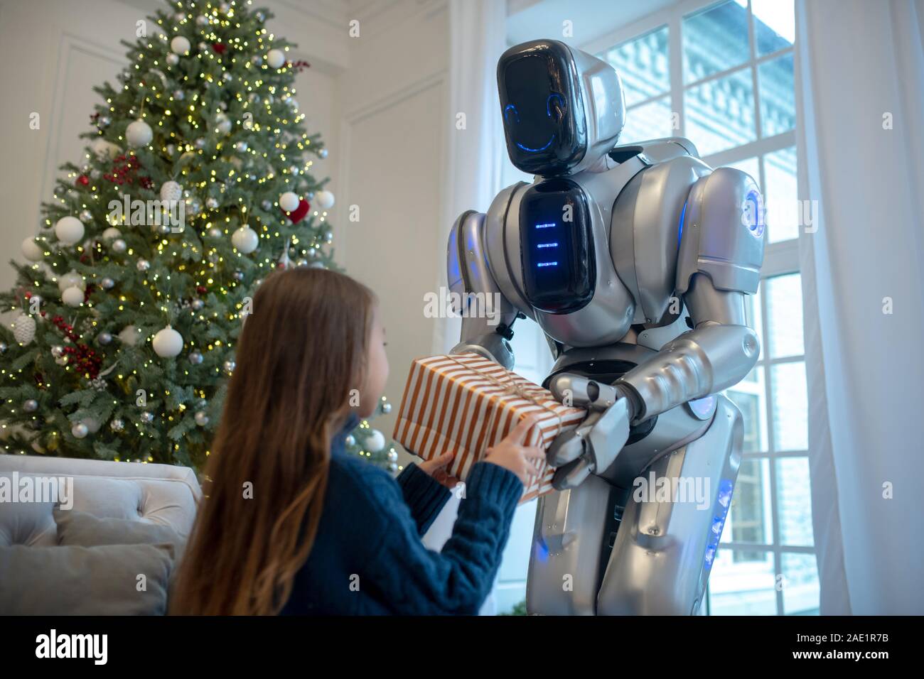 Robot giving a christmas present to a girl Stock Photo - Alamy
