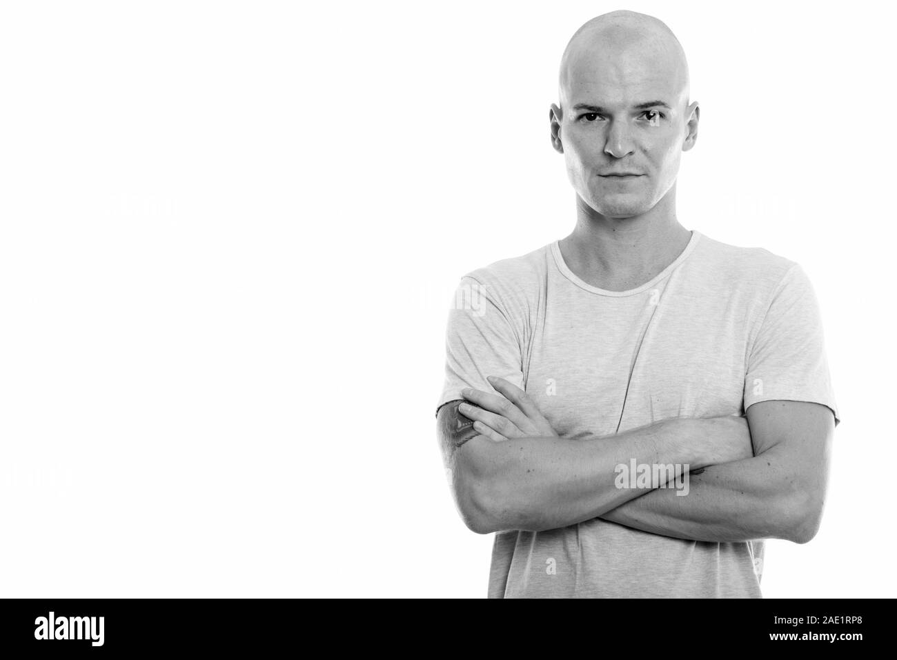 Studio shot of young handsome bald man with arms crossed Stock Photo ...