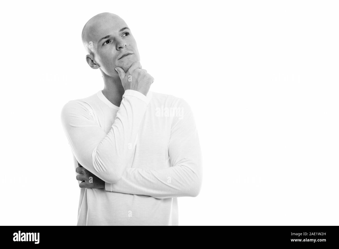 Studio shot of young handsome bald man thinking Stock Photo - Alamy