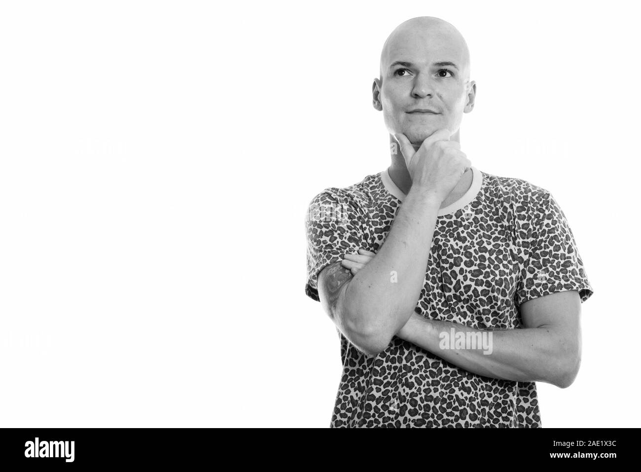 Studio shot of young handsome bald man thinking while looking up Stock ...