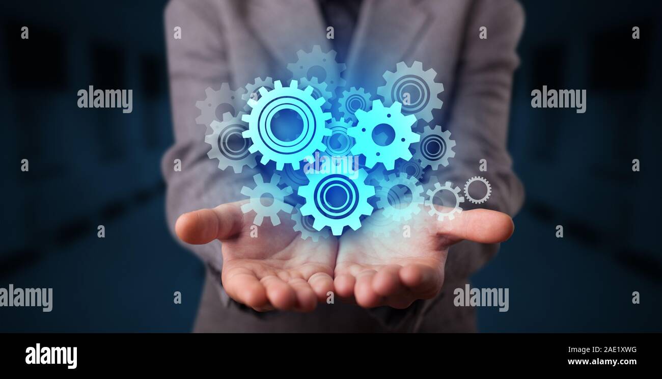 Hand holding gears in his hand Stock Photo - Alamy