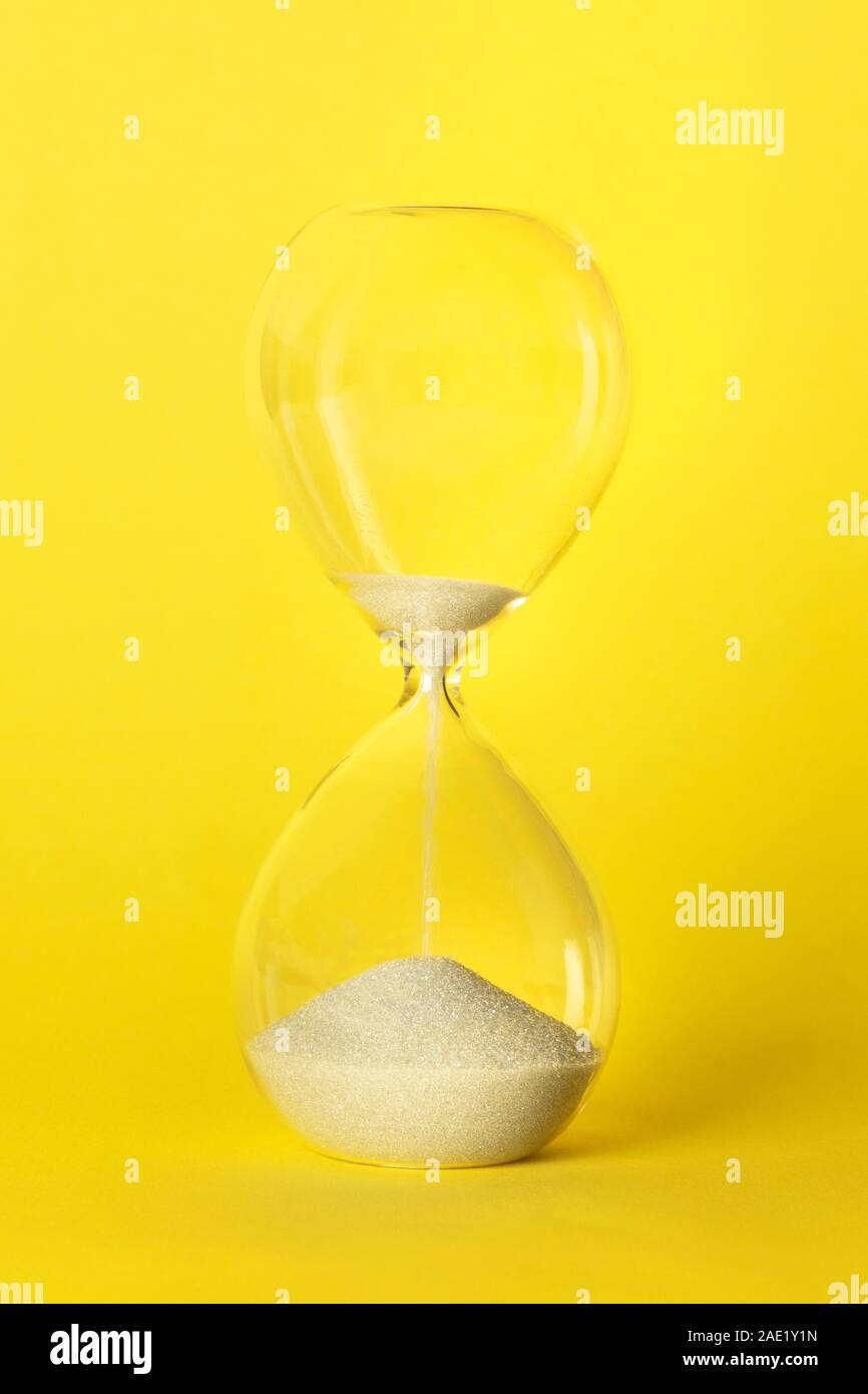 Time is running out concept. An hourglass with sand dripping through ...