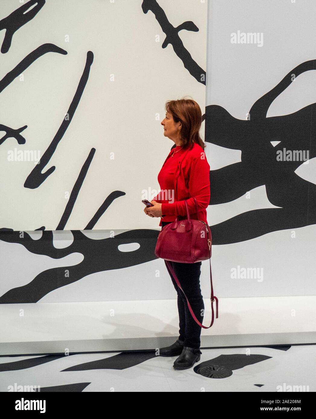 Woman standing by art by Brian Donnelly aka KAWS sculptor and graffiti ...