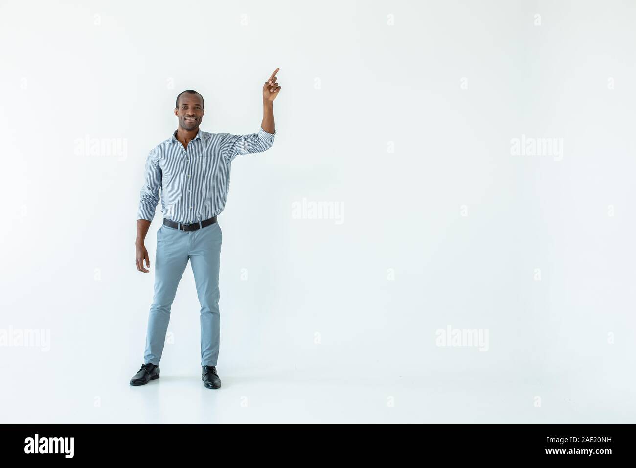 Positive afro american man pointing up against white background Stock ...