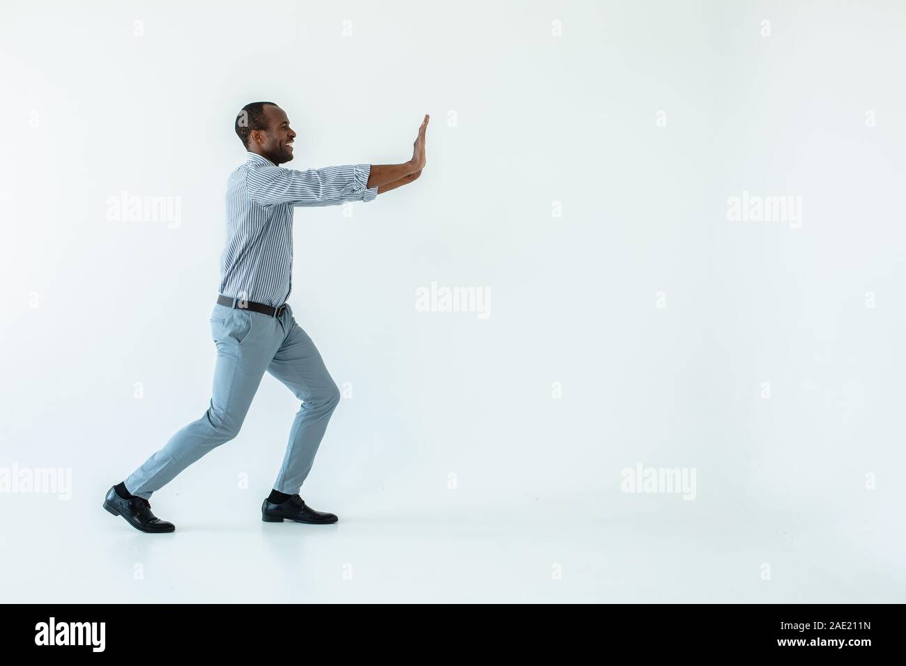 Positive afro american man pushing blocks Stock Photo - Alamy