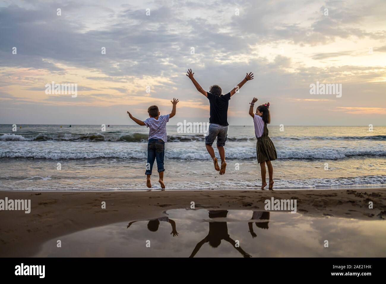 Kids jumping beach sunset hi-res stock photography and images - Alamy