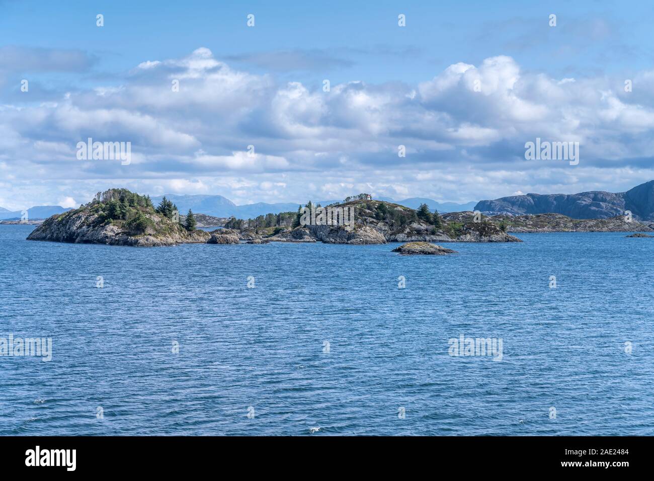 fjord landscape with small light house on green rocky cliff, shot under ...