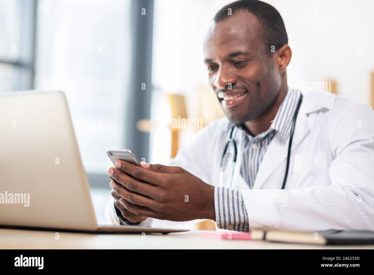 Handsome international man keeping smile on face Stock Photo - Alamy