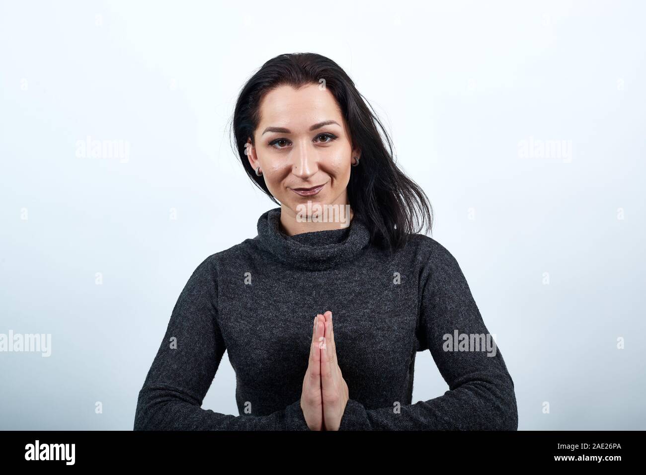 Charming caucasian woman keeping hands together, praying. Lifestyle ...