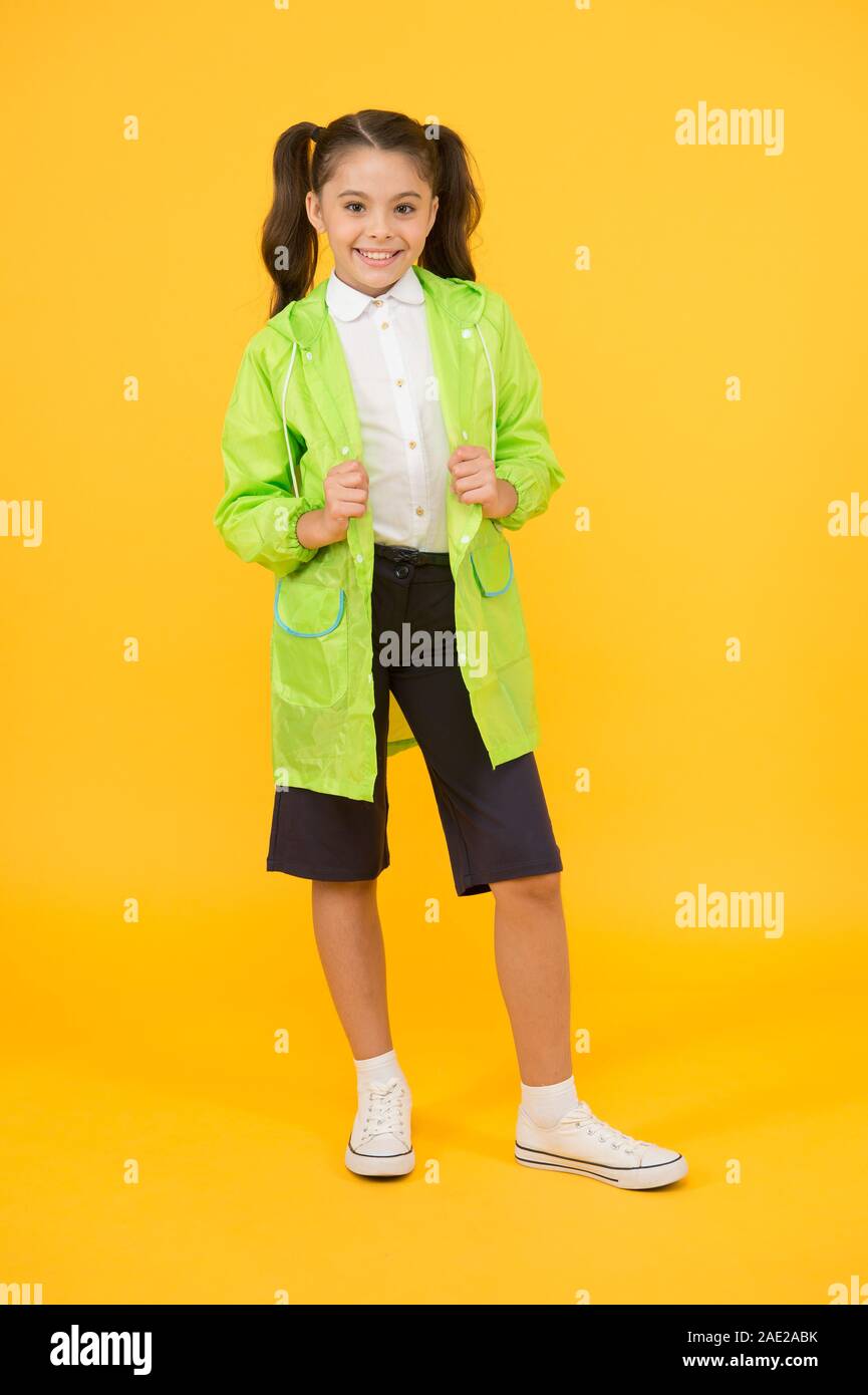 Happy schoolgirl wear raincoat. Invest in durable kids rainwear to keep ...