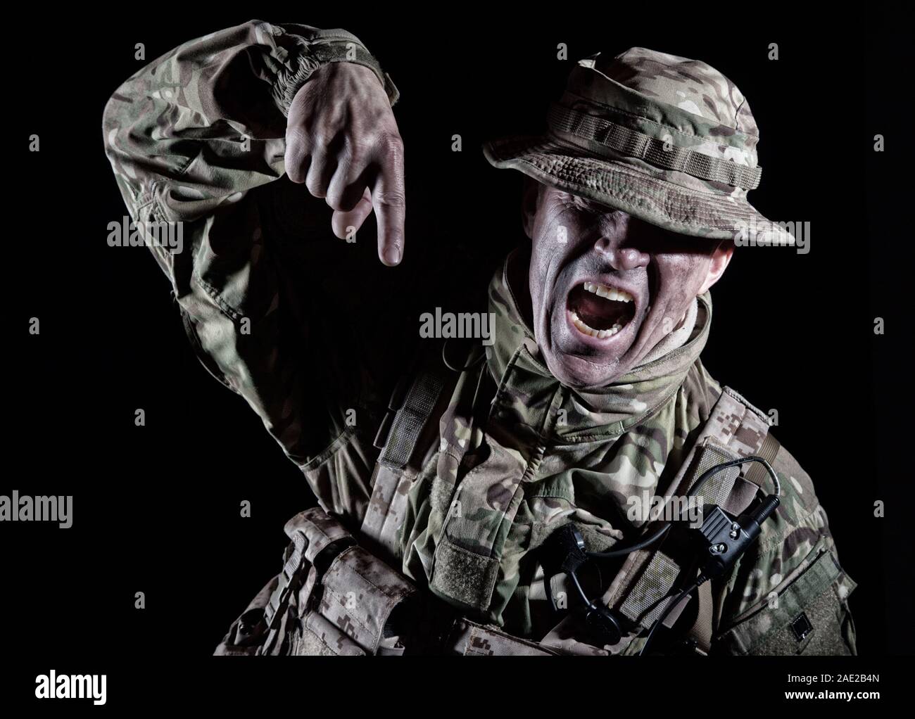 Soldier pointing finger down on black background Stock Photo - Alamy