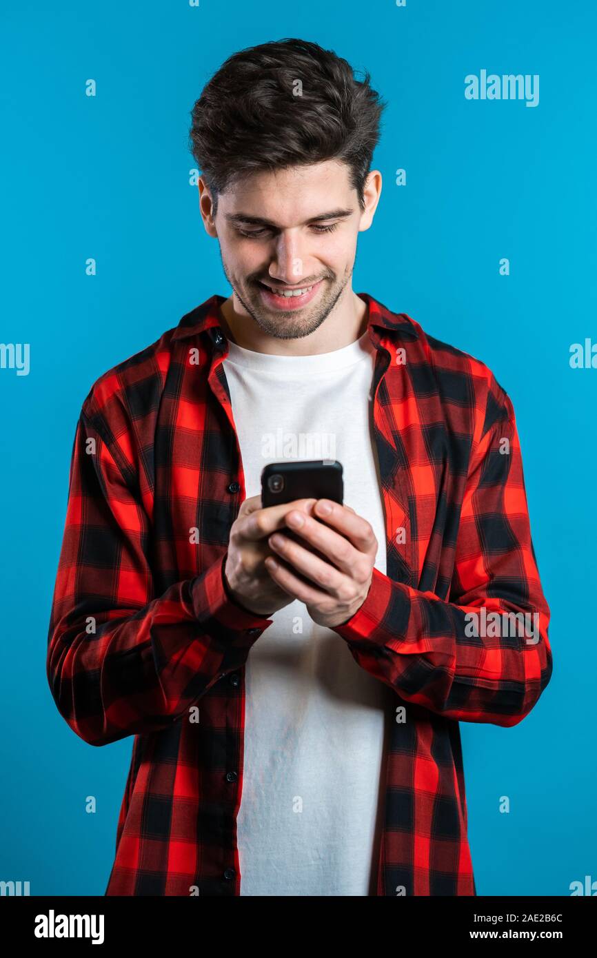 Man sms texting using app on smartphone. Handsome young guy surfing ...