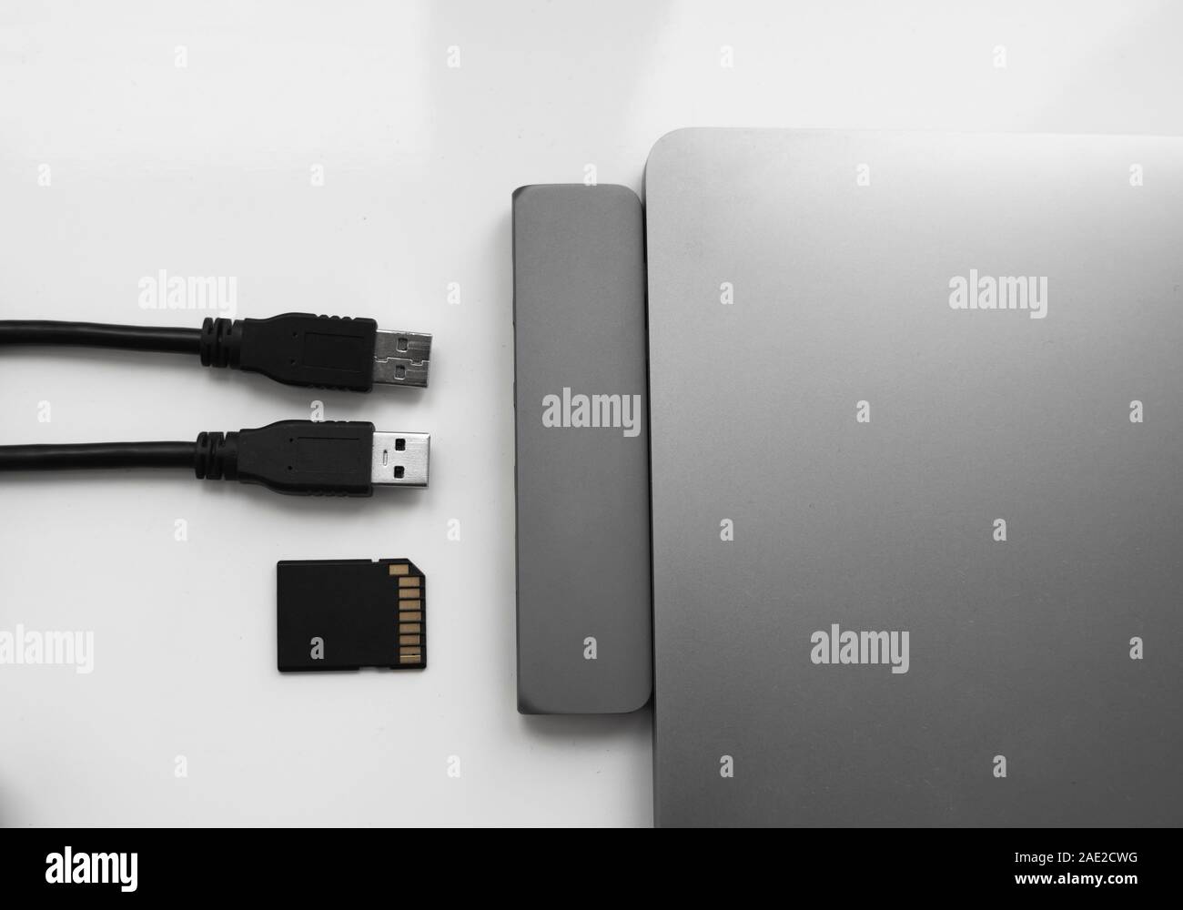Laptop with USB Type-C adapter with pluged USB cables and SD card. The ...