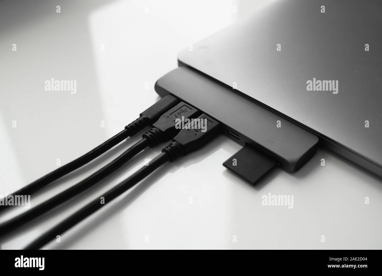 Laptop with USB Type-C adapter with pluged USB cables and SD card. The ...