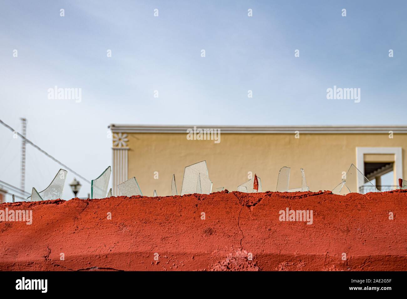 glass shards embedded ion top of red wall to stop intruders Stock Photo ...