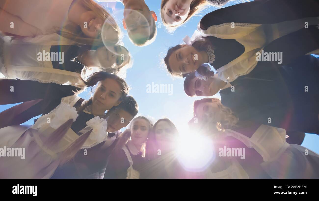 Happy friends connected in a ring together. View from the bottom. The ...