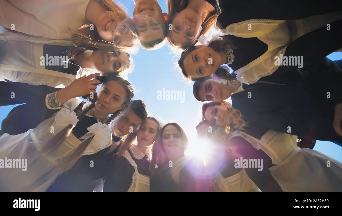 Happy friends connected in a ring together. View from the bottom. The ...