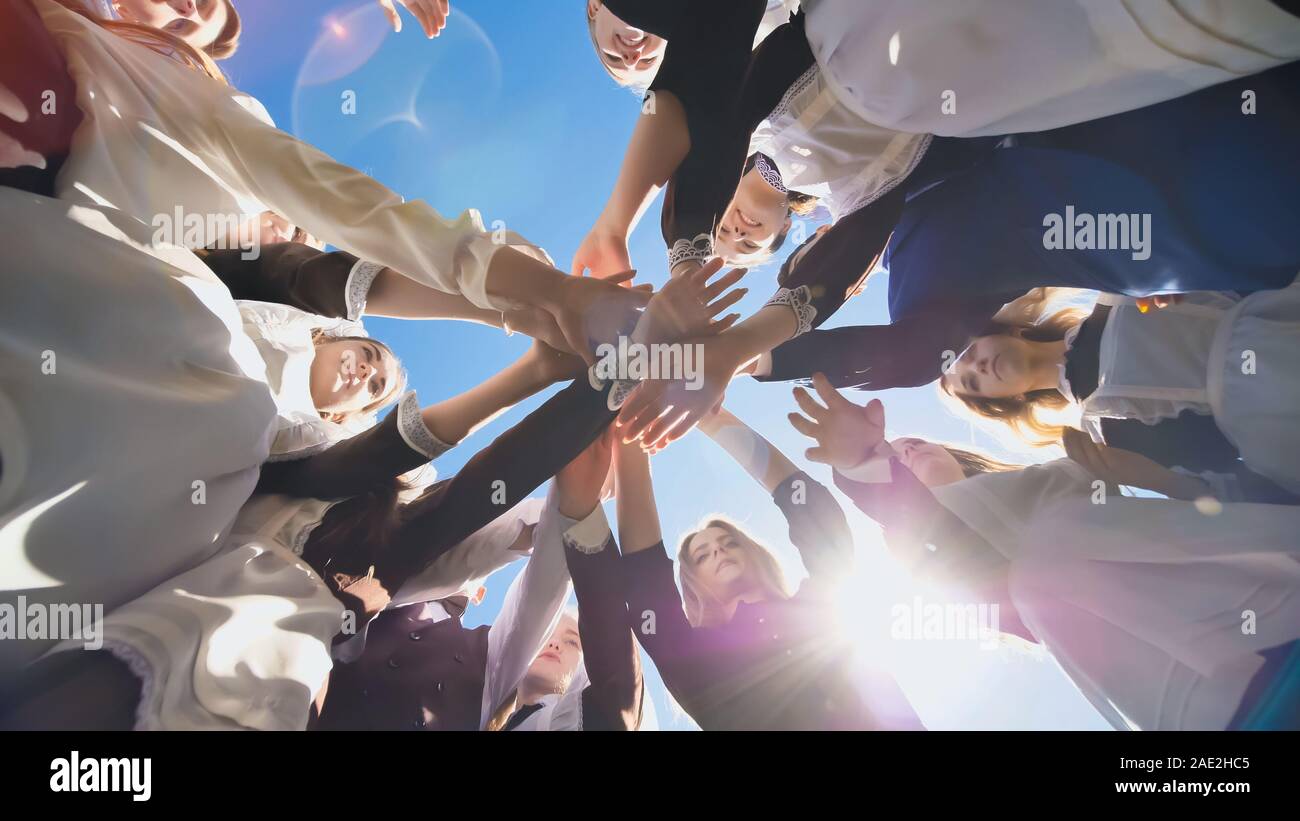 Happy friends graduates join hands together. The concept of a friendly ...