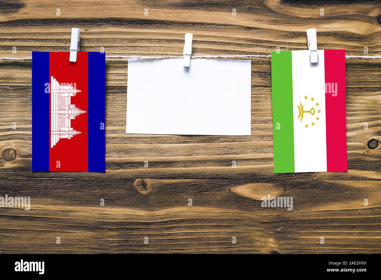 Hanging flags of Cambodia and Tajikistan attached to rope with clothes ...